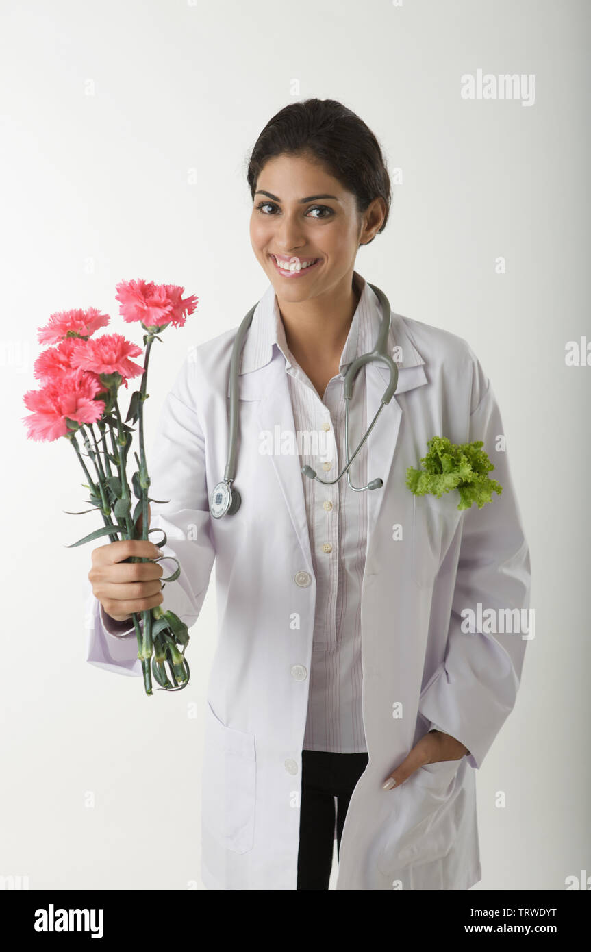 Female doctor holding bunch of flowers and smiling Stock Photo - Alamy