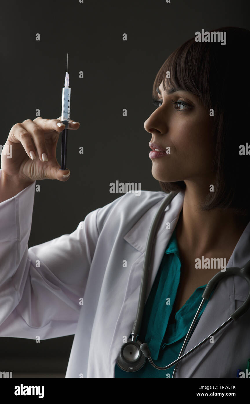 Female doctor holding a syringe Stock Photo - Alamy