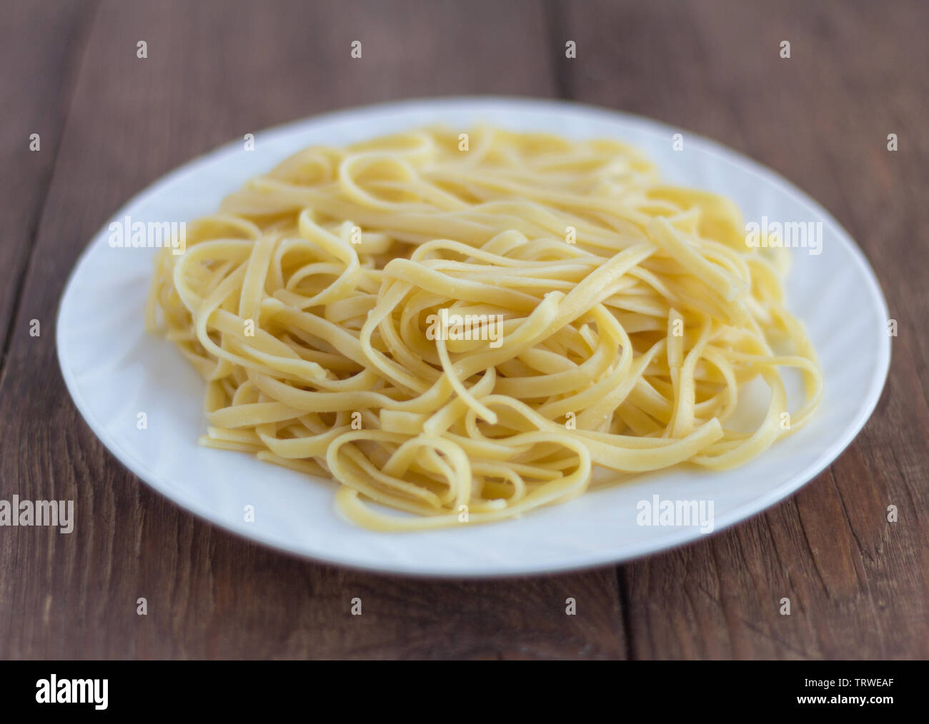 pasta, plate of cooked spaghetti on wooden background Stock Photo - Alamy