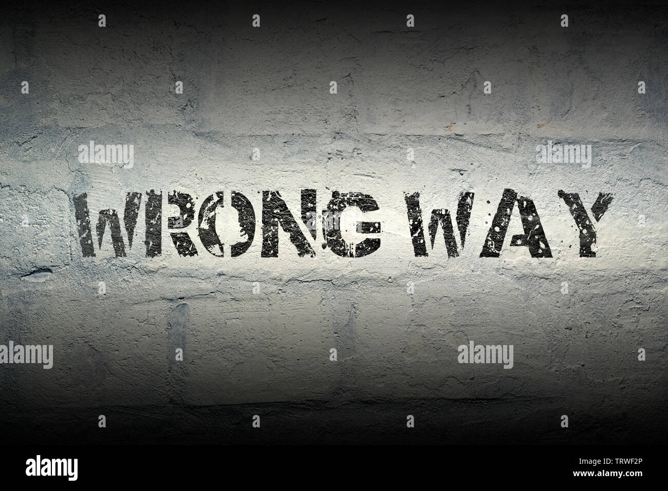 wrong way black stencil print on the grunge brick wall with gradient ...