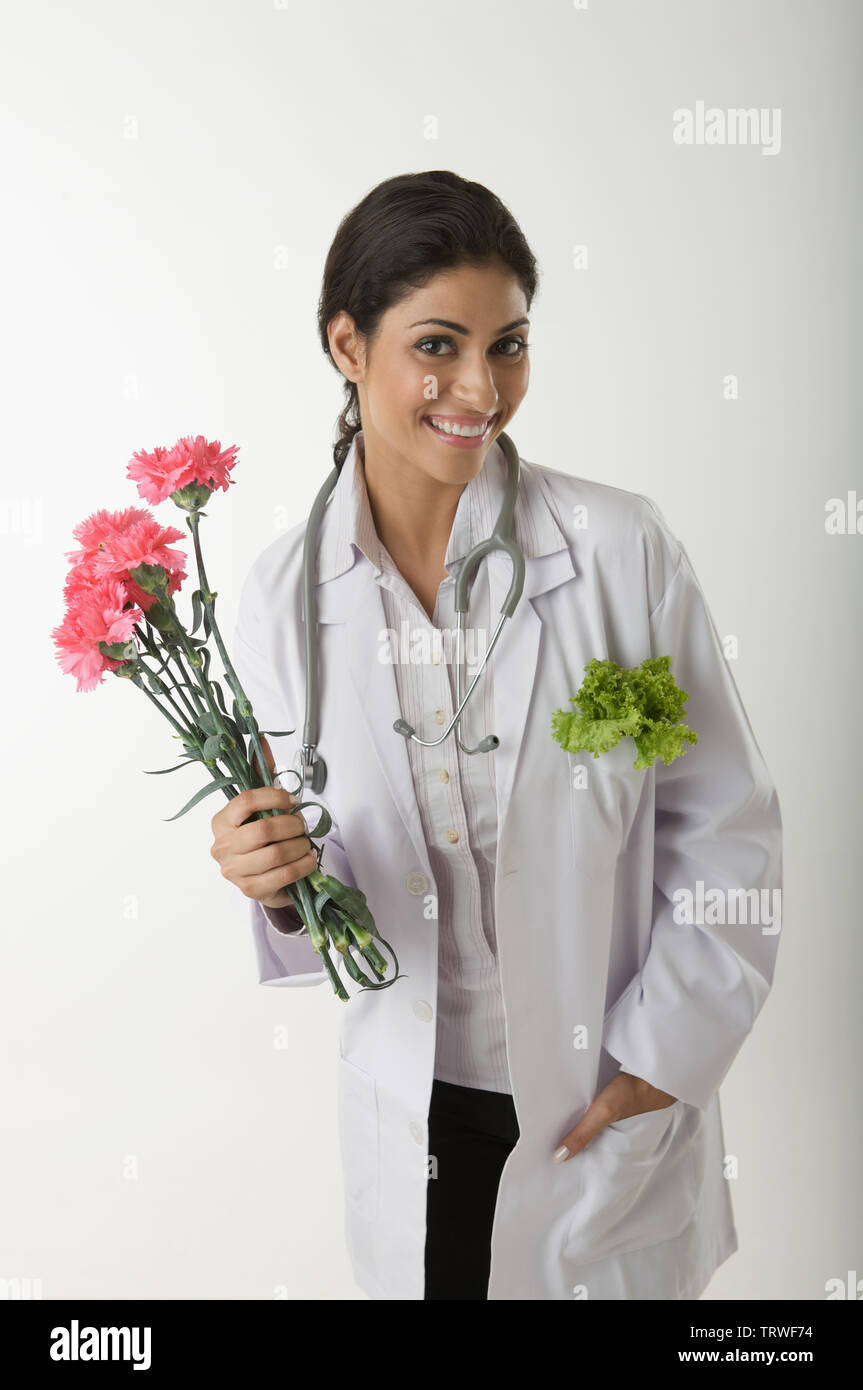 Female doctor holding bunch of flowers and smiling Stock Photo - Alamy
