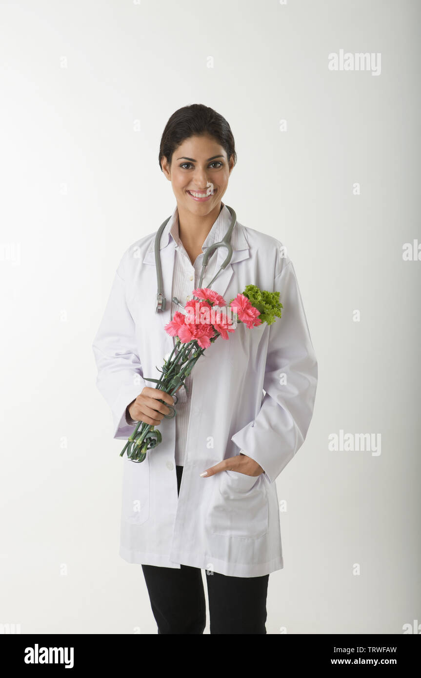 Female doctor holding bunch of flowers and smiling Stock Photo - Alamy