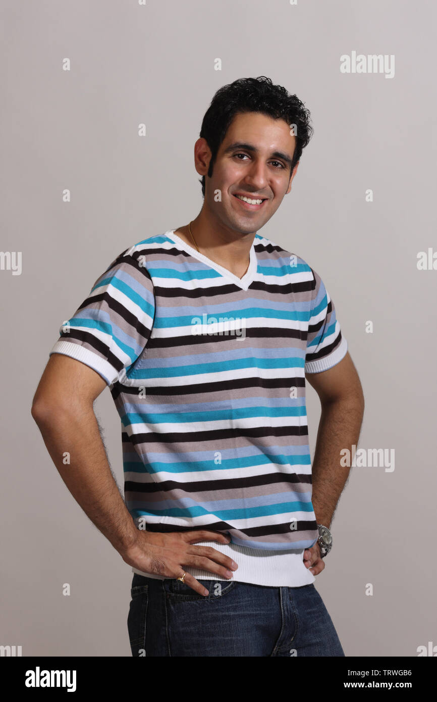 Portrait of a man standing with arms akimbo Stock Photo - Alamy