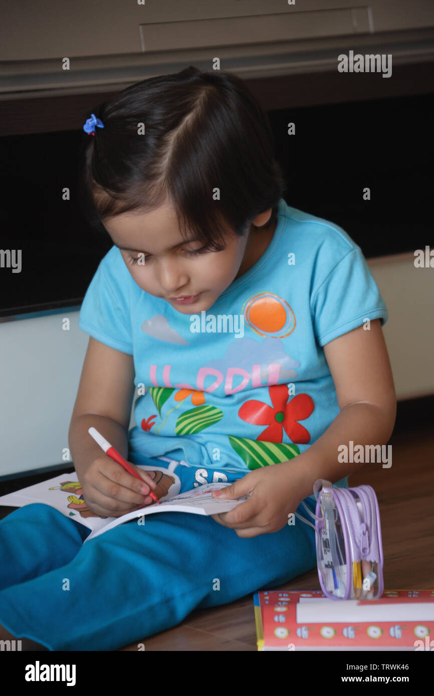 Girl coloring in a book Stock Photo - Alamy