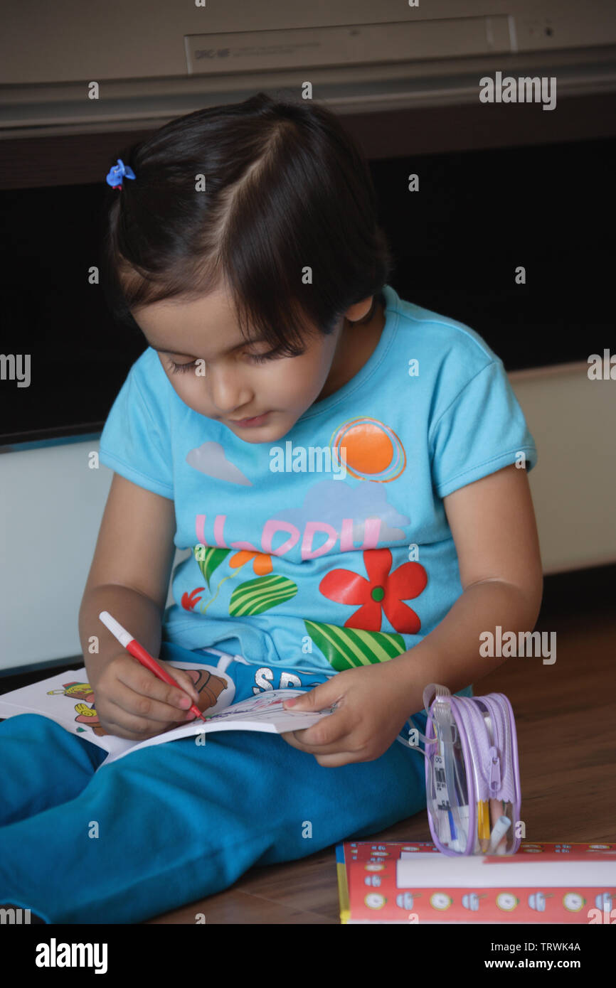 Girl coloring in a book Stock Photo - Alamy