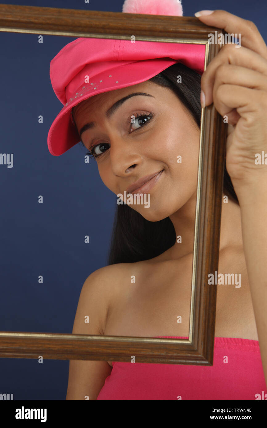 Woman looking through a picture frame Stock Photo - Alamy