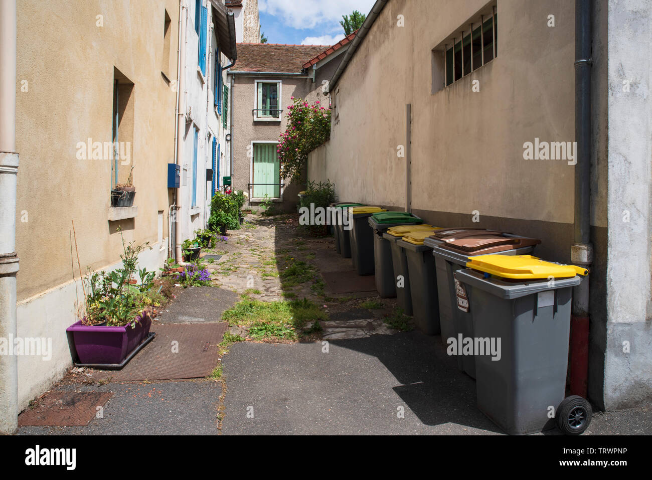 Garbage bins in a city centre in front of houses Stock Photo - Alamy