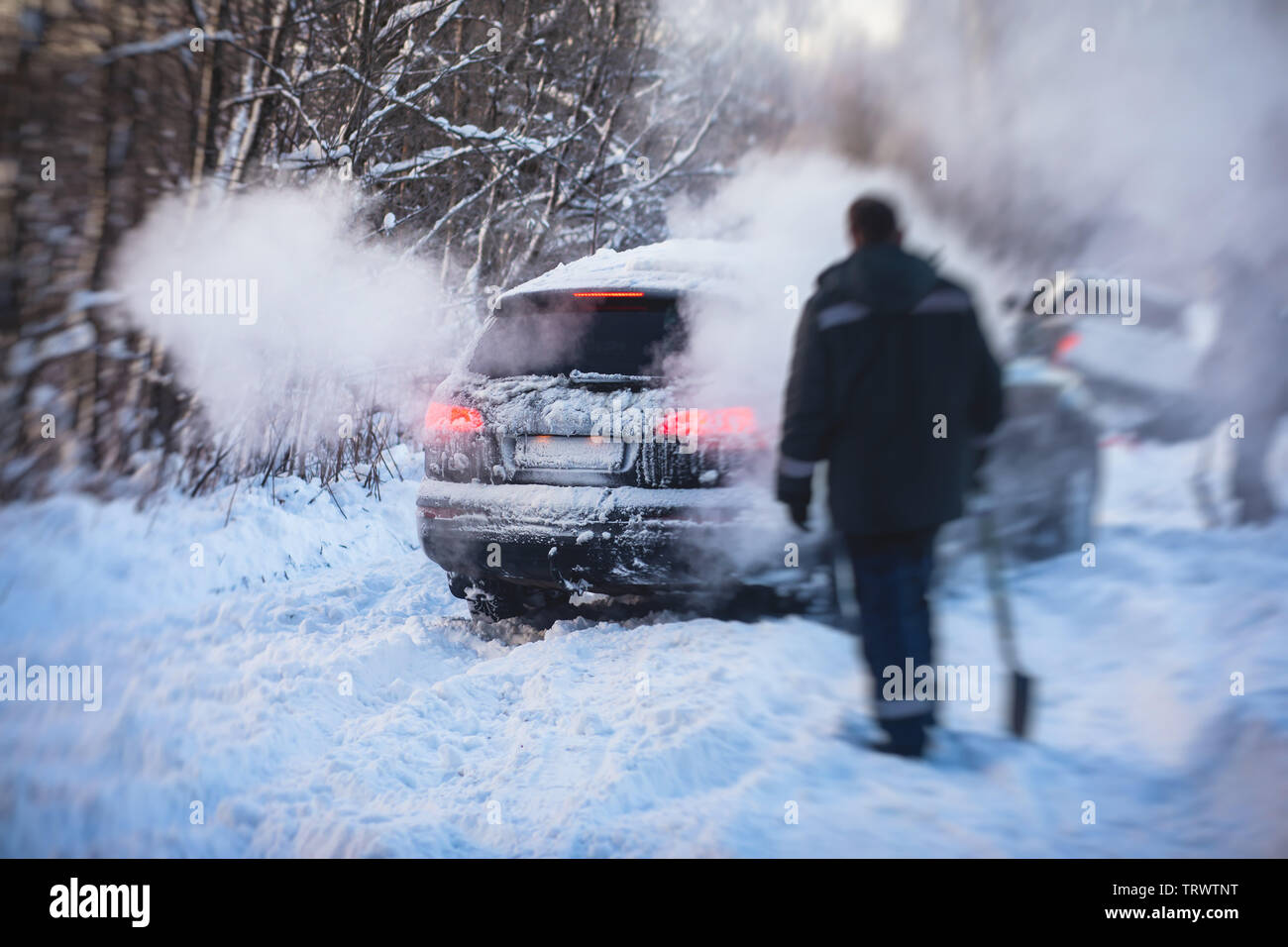 Process of taking out suv car stuck in snow, men digging and pushing ...
