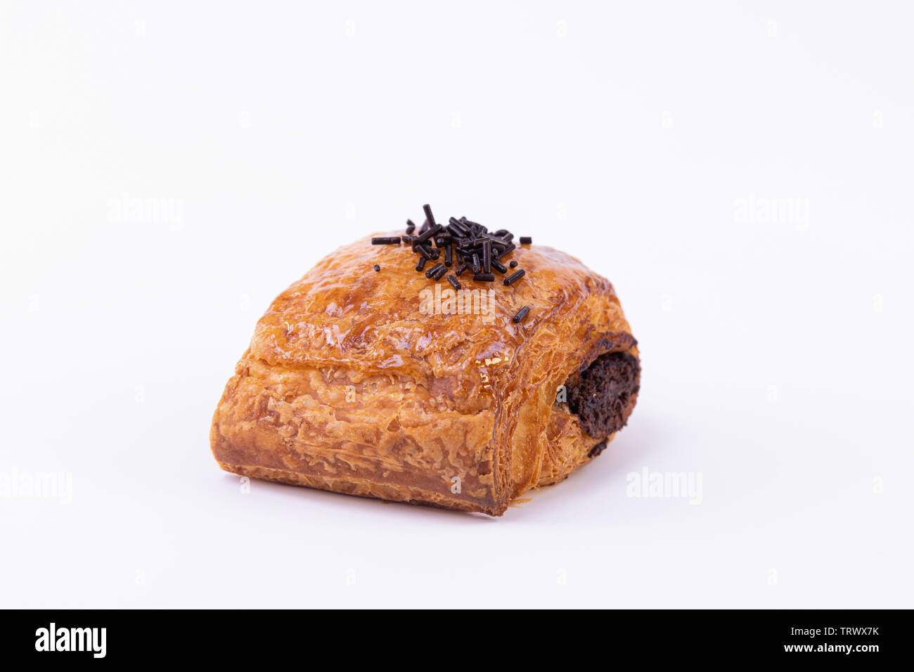 Side view of a puff pastry roll filled with chocolate on a white ...