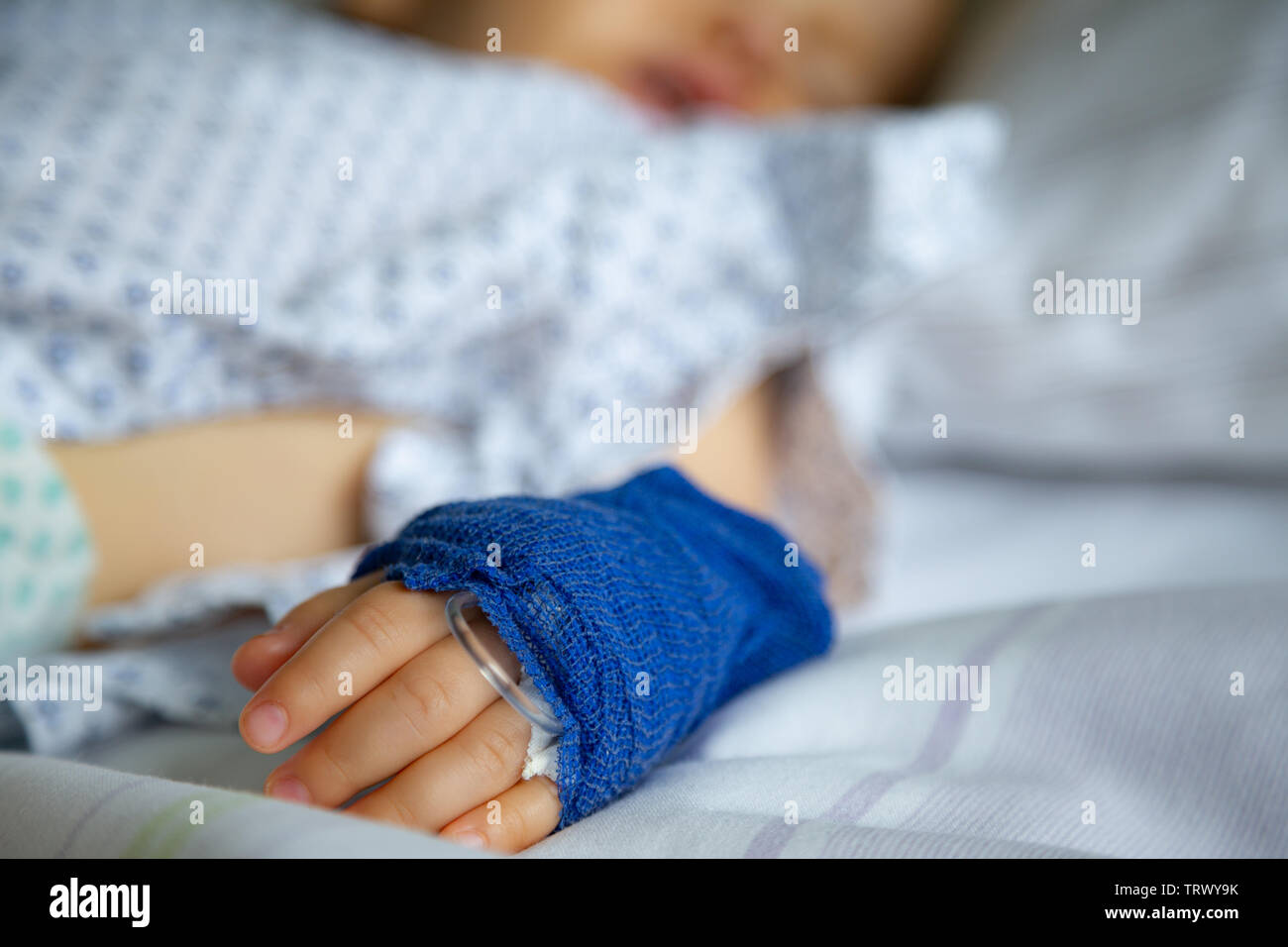 Sleeping sick child with peripheral venous line on his left hand in ...