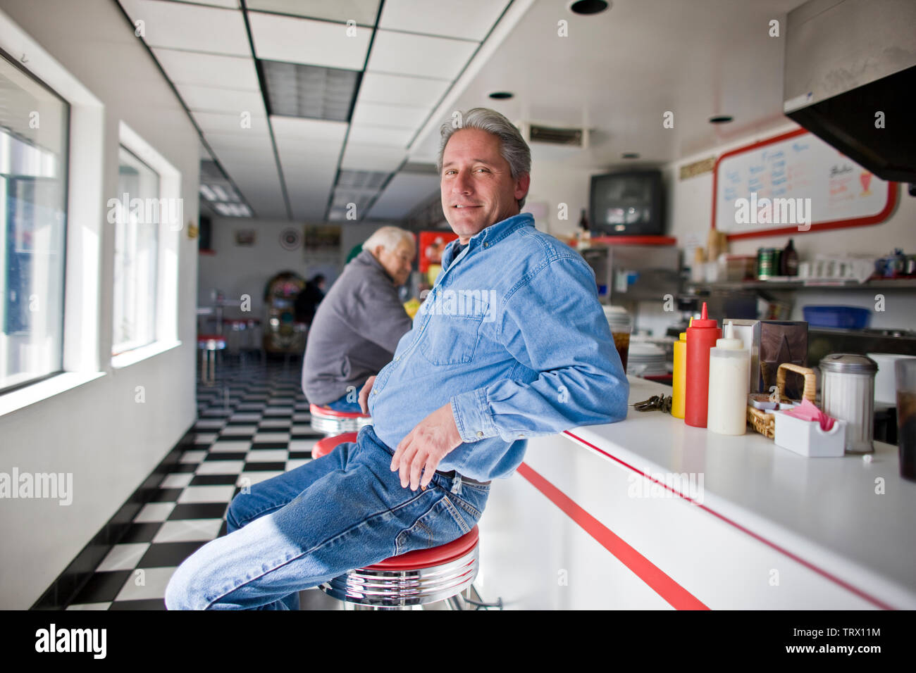 Portrait of a smiling mature man in a diner Stock Photo - Alamy