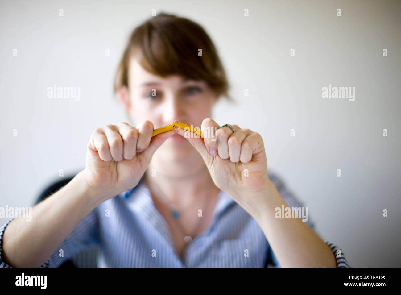 Portrait of a frustrated young office worker snapping a pencil in half ...