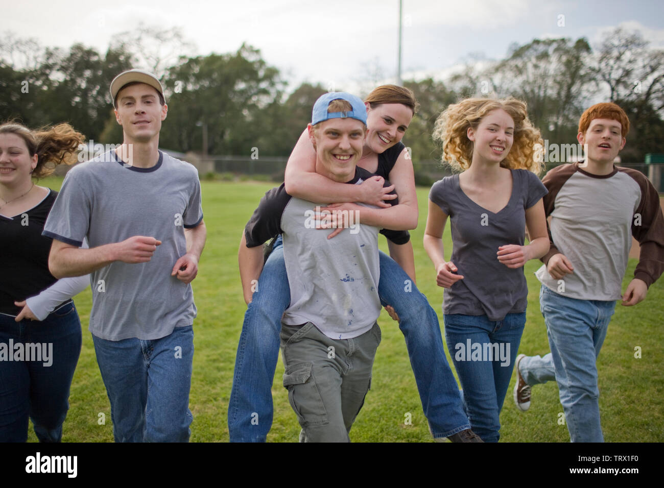 Friends running across sport field Stock Photo - Alamy