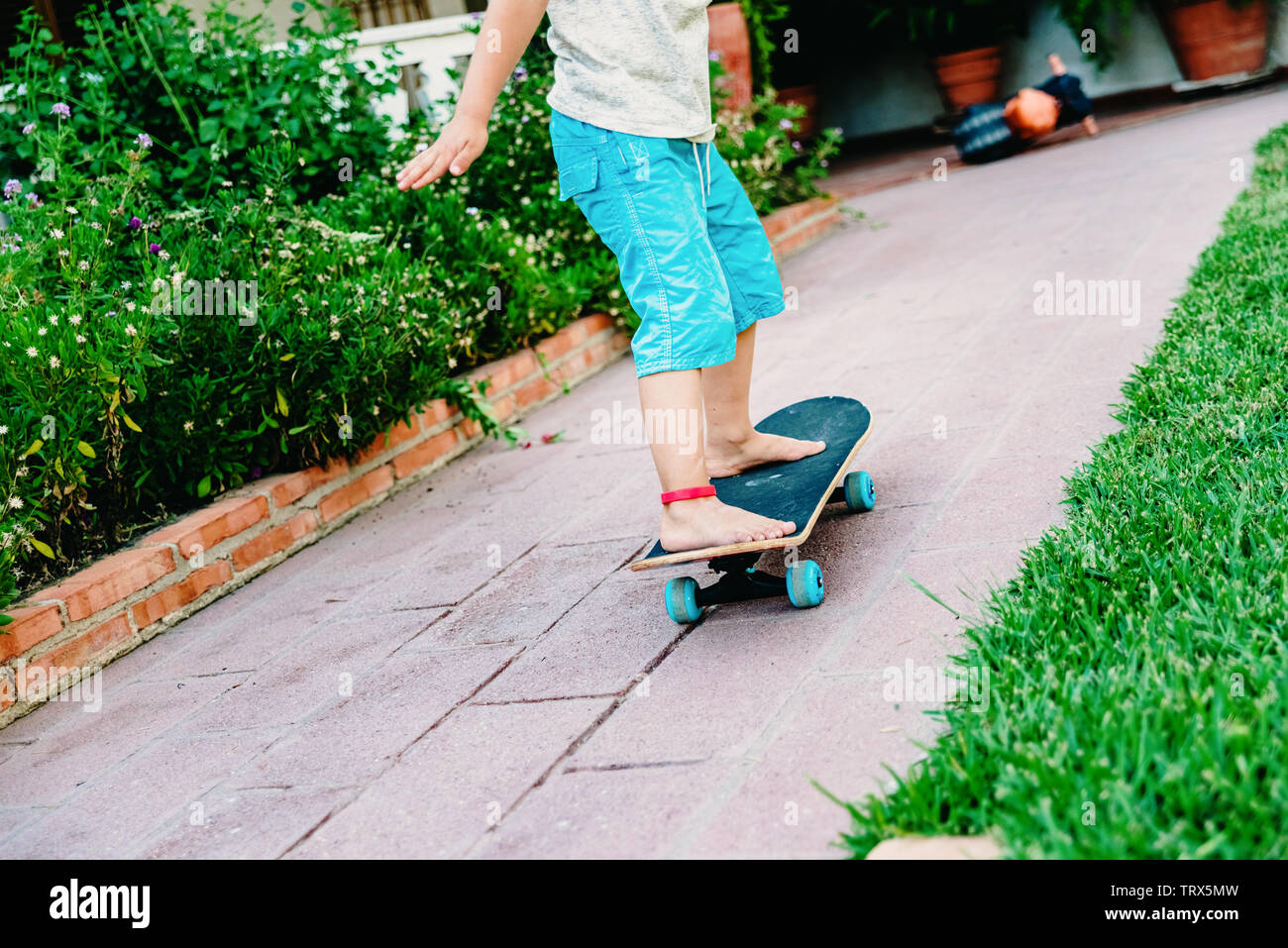 5 year old boy practicing skate in his backyard, stumbling and falling ...