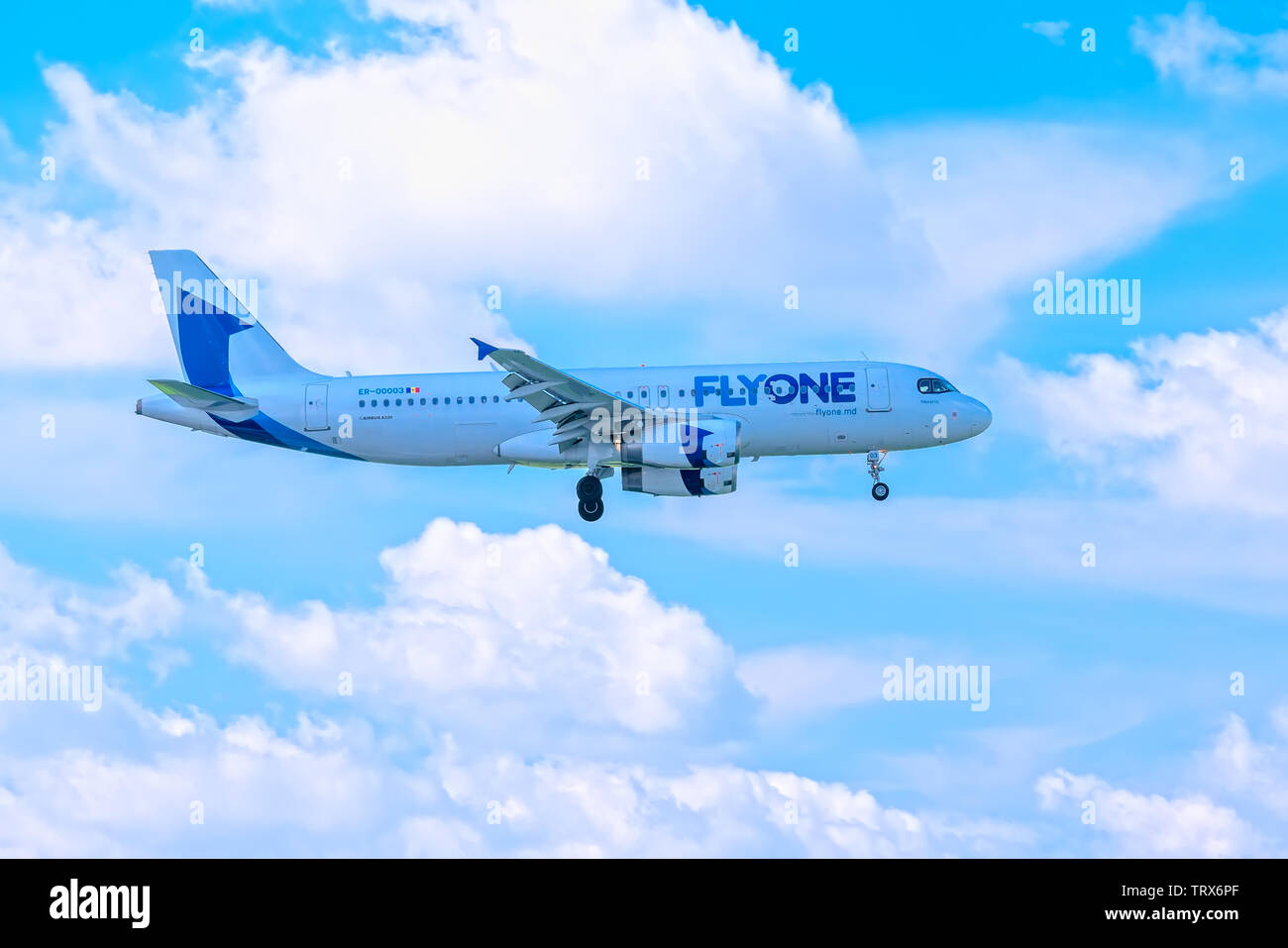 Passenger airplane Airbus A320 of Flyone airline flying over urban ...