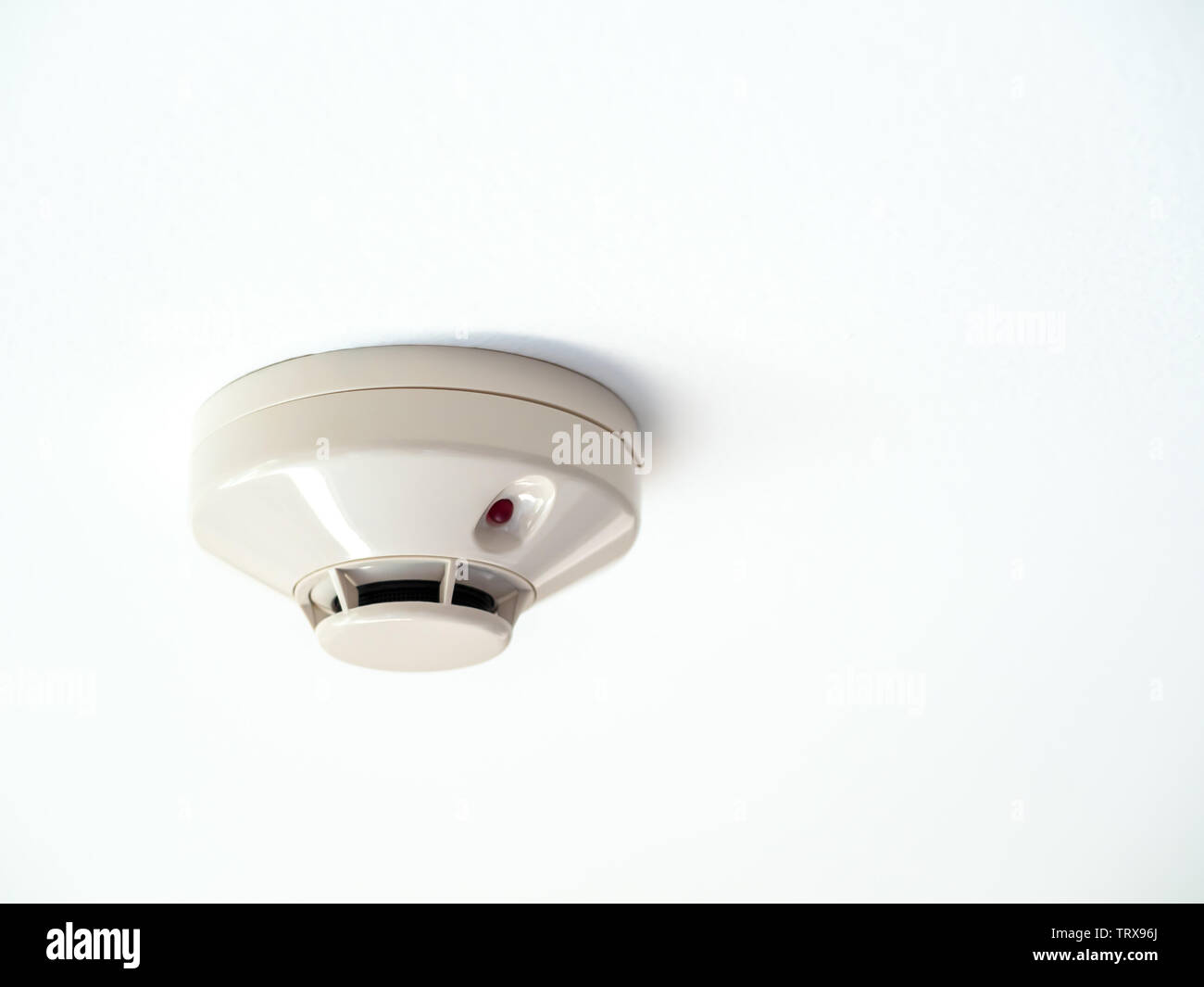 Smoke detector isolated on white ceiling background with copy space ...