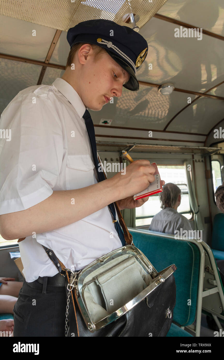 Train conductor selling tickets to Heinola in a vintage railbus in ...