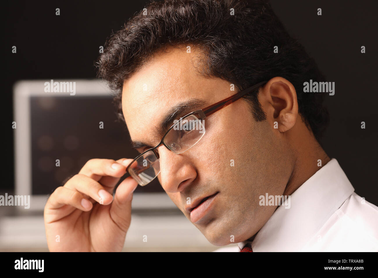 Close up of an young businessman adjusting eyeglasses Stock Photo - Alamy