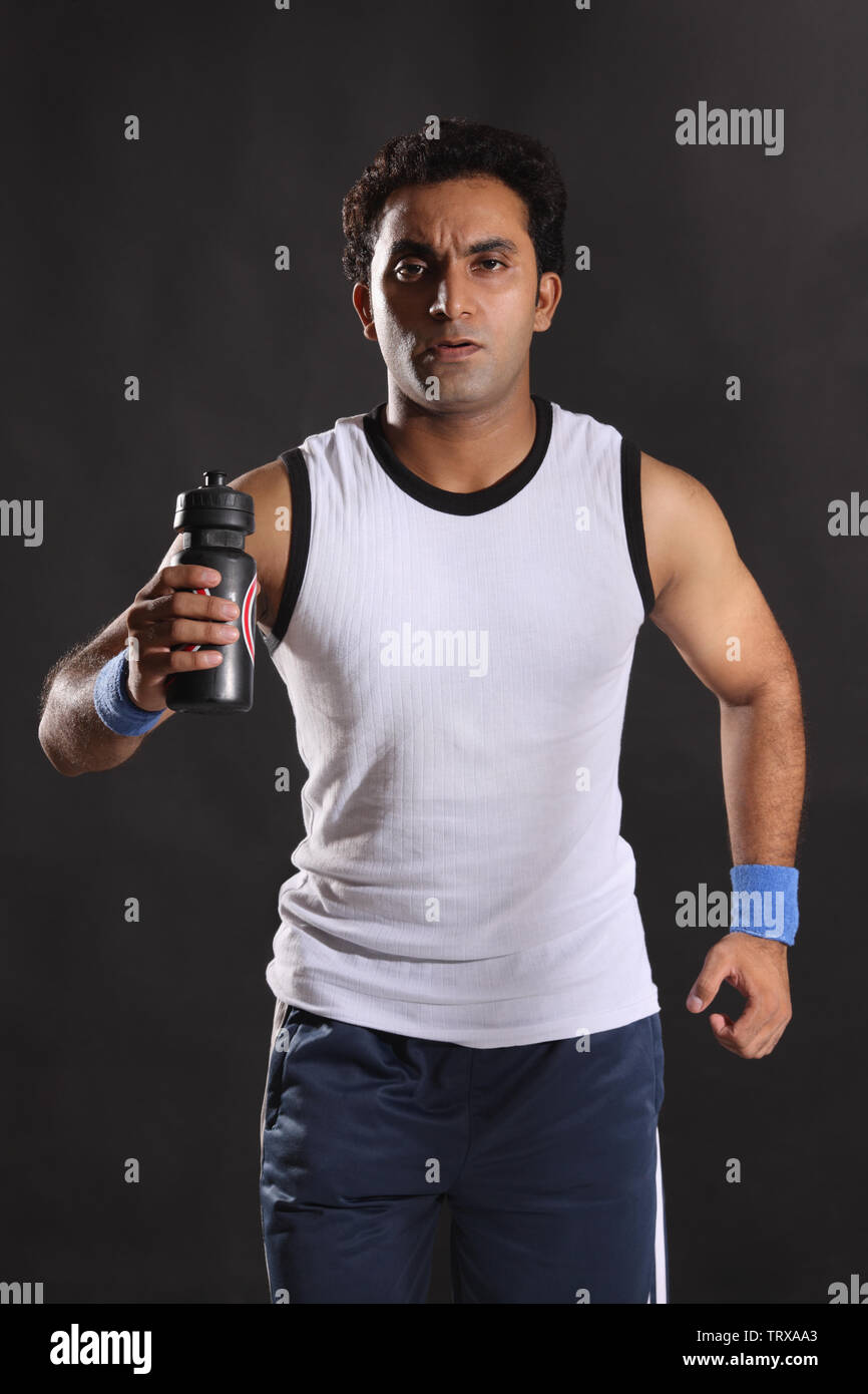 Portrait of a male athlete holding a sport drink Stock Photo - Alamy