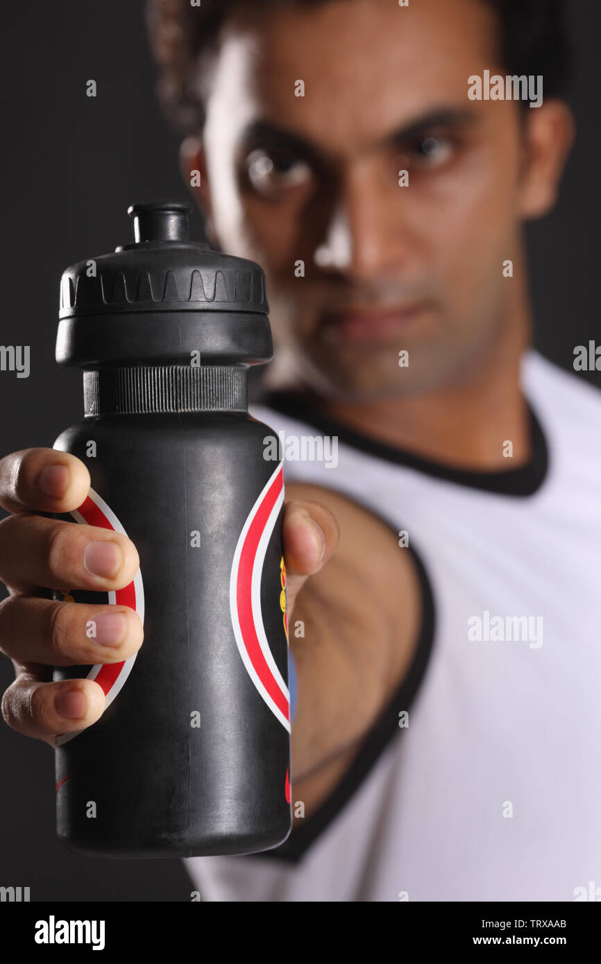 Portrait of a male athlete holding a sport drink Stock Photo - Alamy