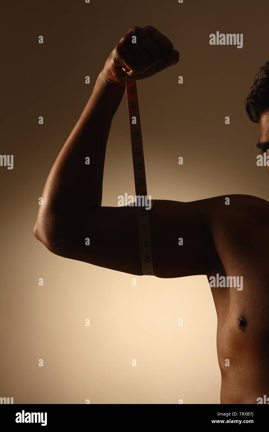 Man measuring his biceps Stock Photo - Alamy