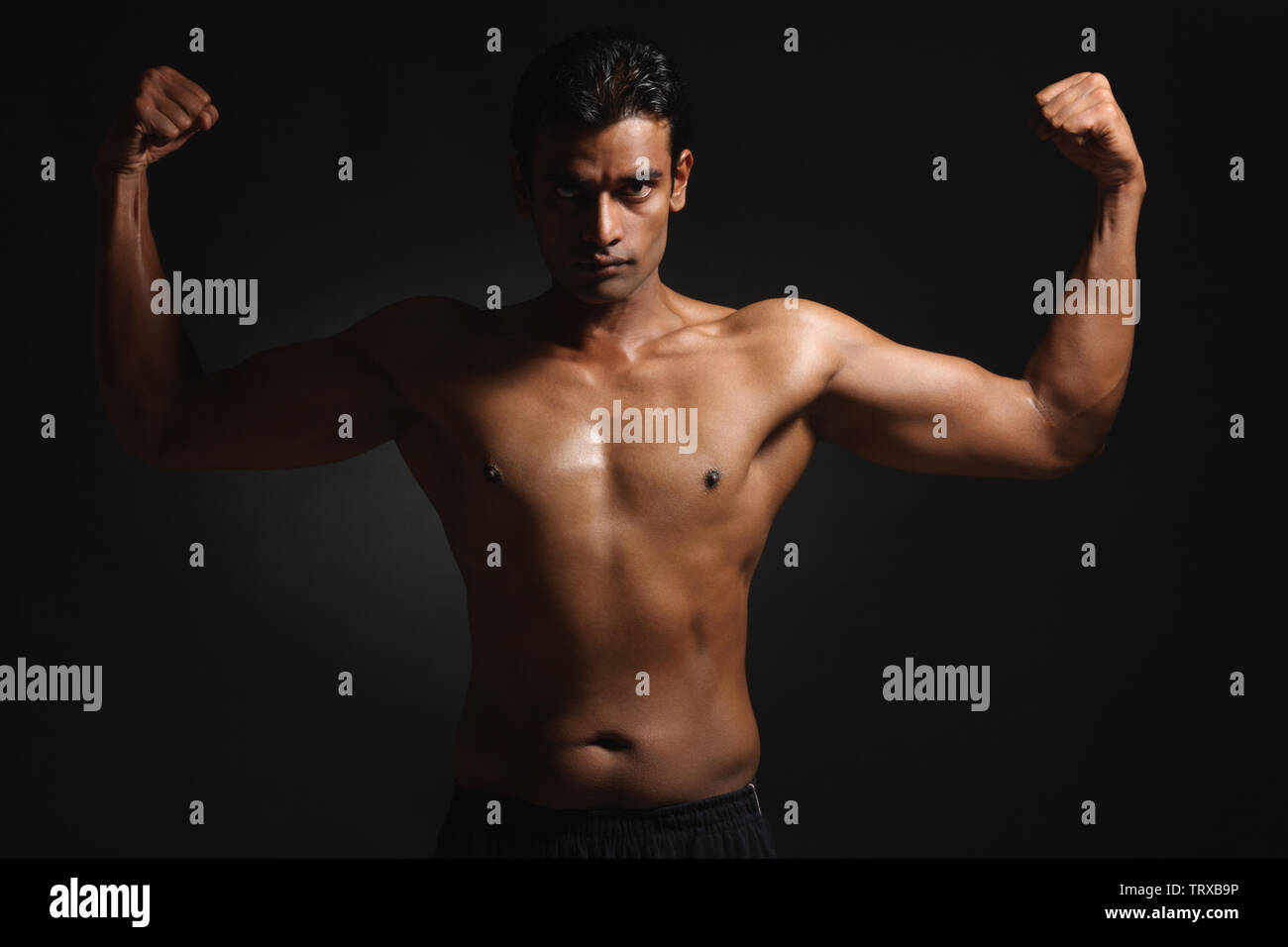 Portrait of a man flexing muscles Stock Photo - Alamy