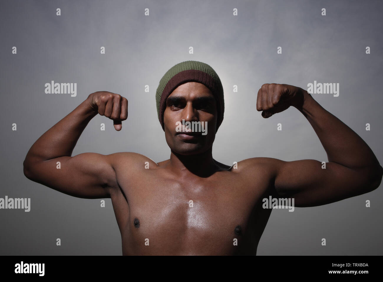 Portrait of a man showing his biceps Stock Photo - Alamy