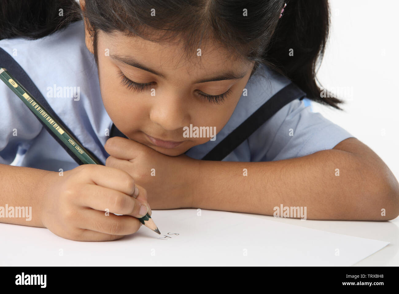 Girl writing in a piece of paper Stock Photo - Alamy