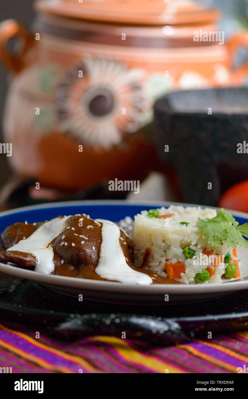 Mexican mole sauce with chicken, rice and black refried beans. Served ...