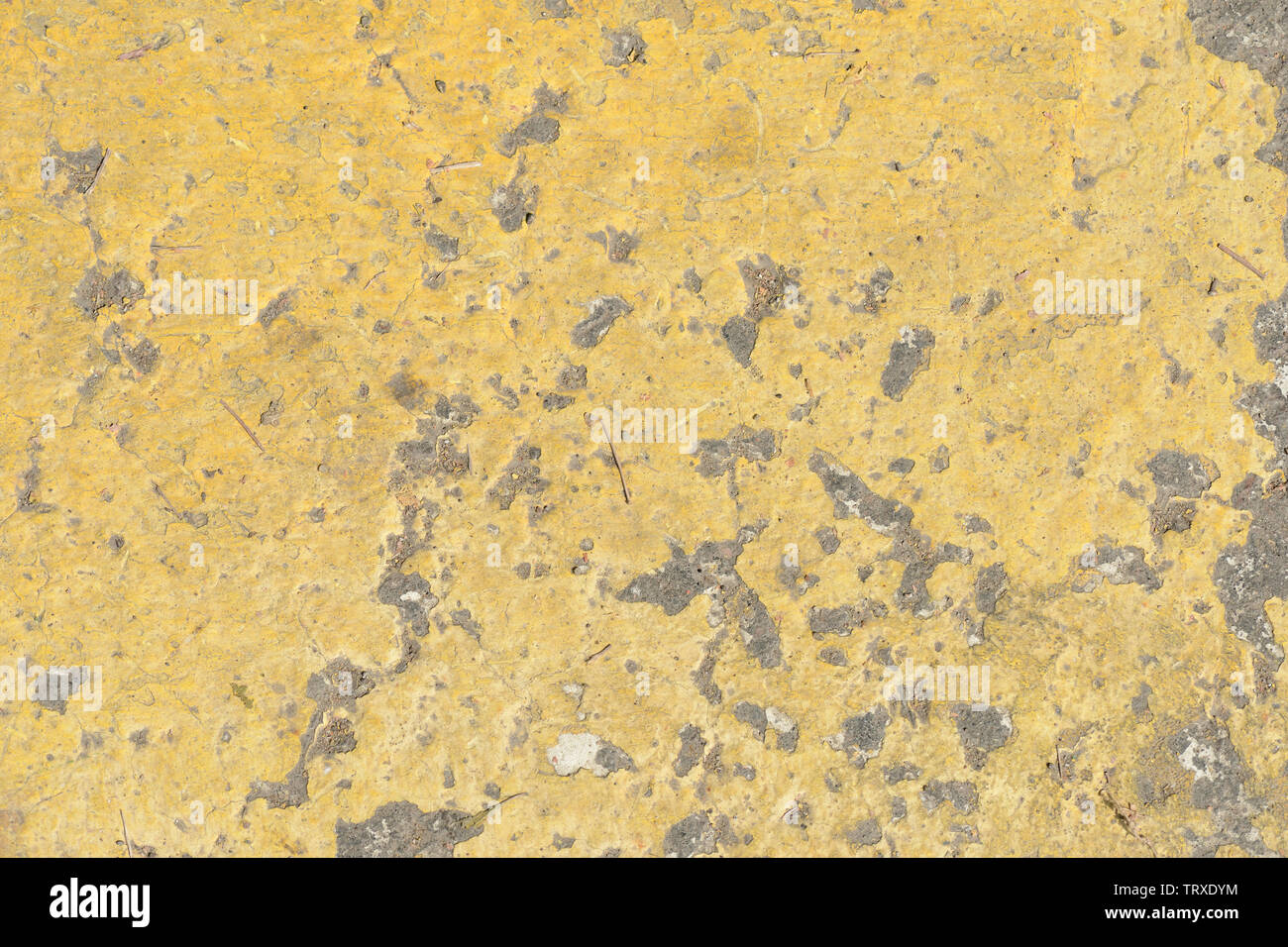 Old asphalt surface with yellow paint on it close up. Abstract ...