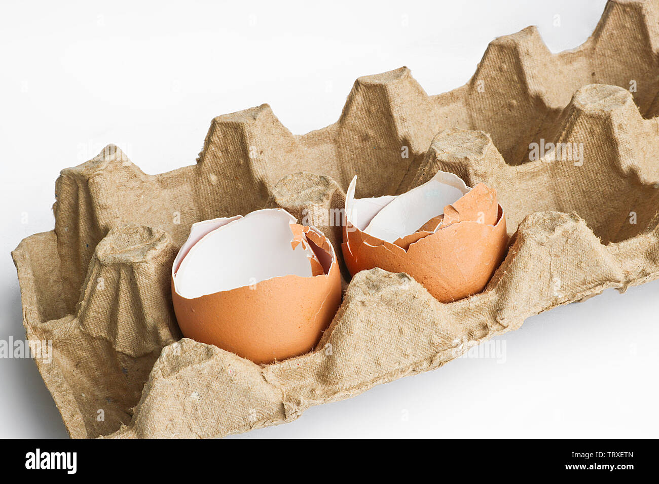 Carton packaging for eggs with broken eggshell on a light background ...