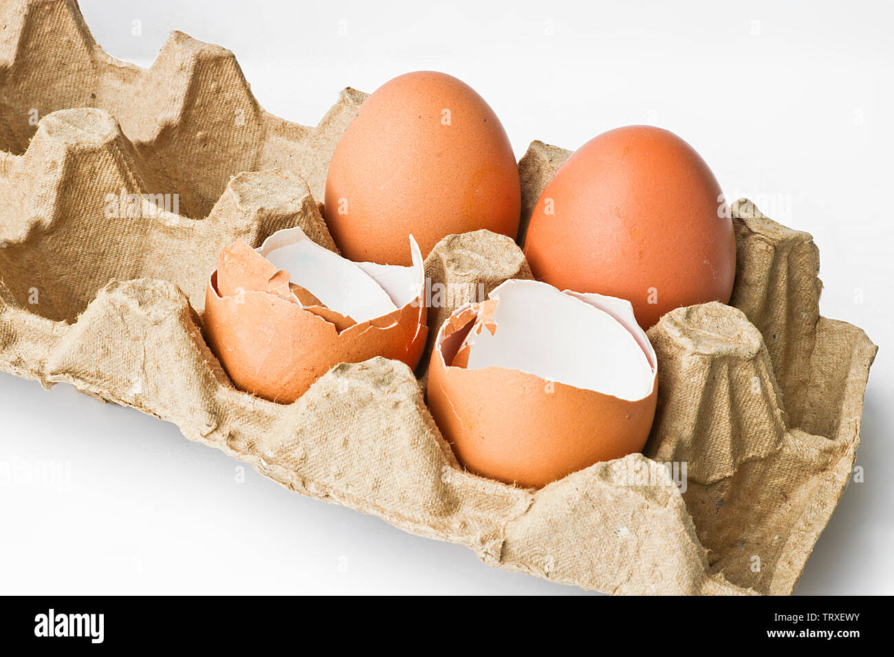 Carton packaging for eggs with broken eggshell and eggs on a light ...