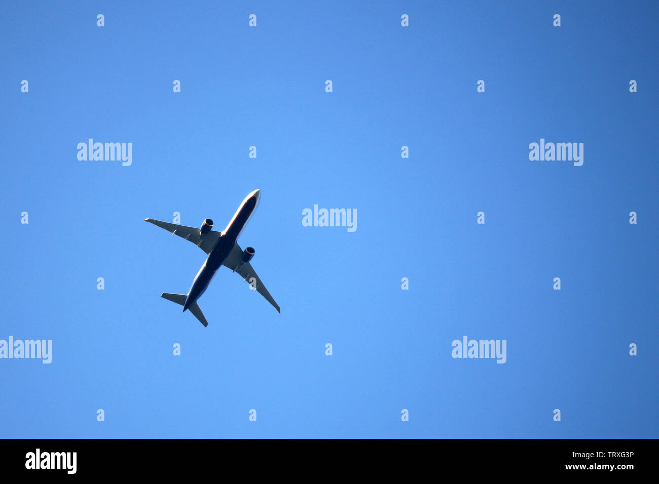 Airplane in the clear blue sky. Commercial jet plane in a flight close ...