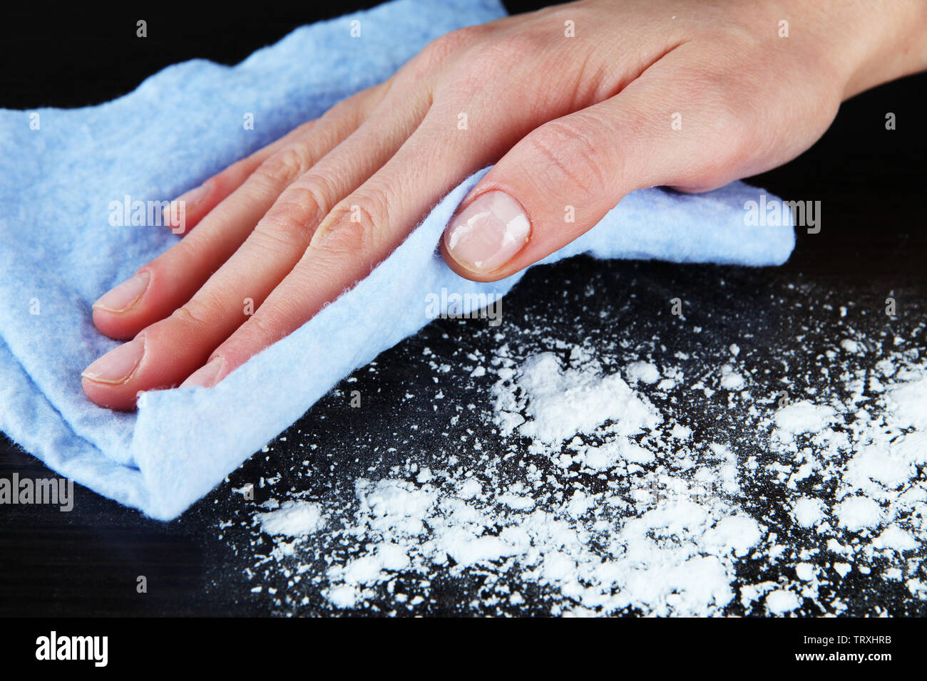 Hand wiping wooden surface with blue rag Stock Photo - Alamy