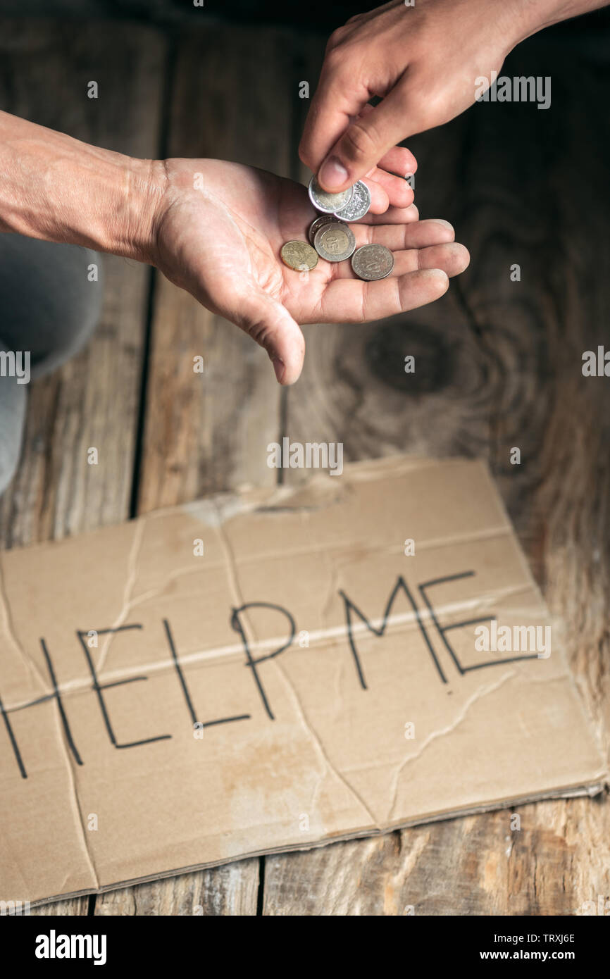 Male beggar hands seeking money with sign HELP ME from human kindness ...