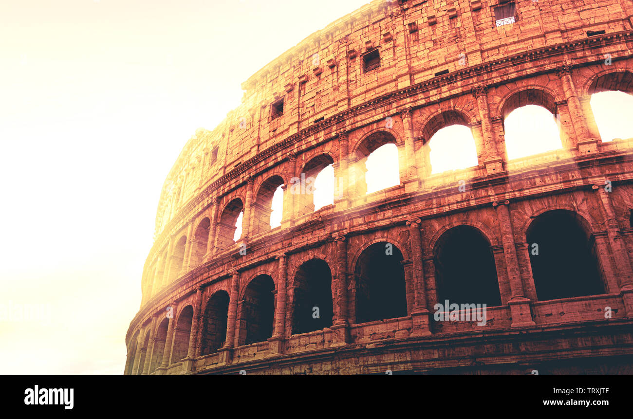 dramatic image of the Colosseum of Rome during sunset with sun rays ...