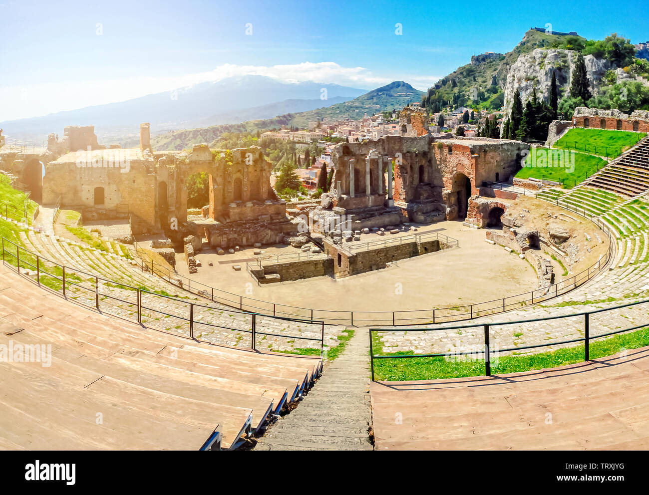 The famous and beautiful ancient greek theatre ruins Taormina with Etna volcano in the distance ...