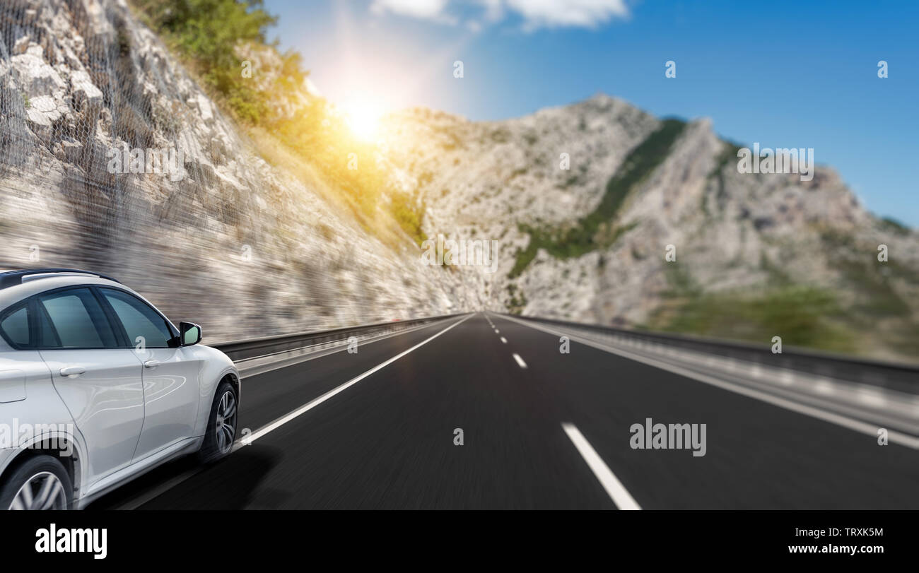 White car rushing along a high-speed highway Stock Photo - Alamy