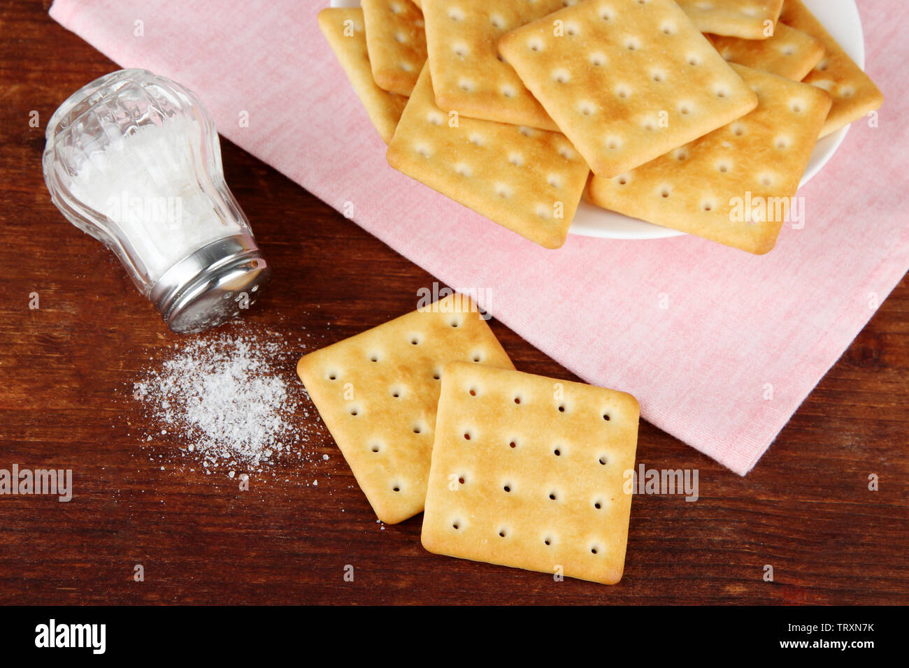Delicious crackers with salt and napkin on wooden background Stock ...