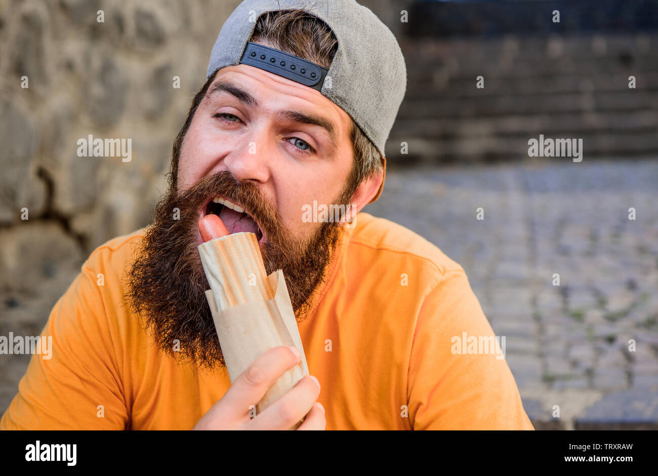 Hungry man snack. Junk food. Guy eating hot dog. Man bearded bite tasty ...