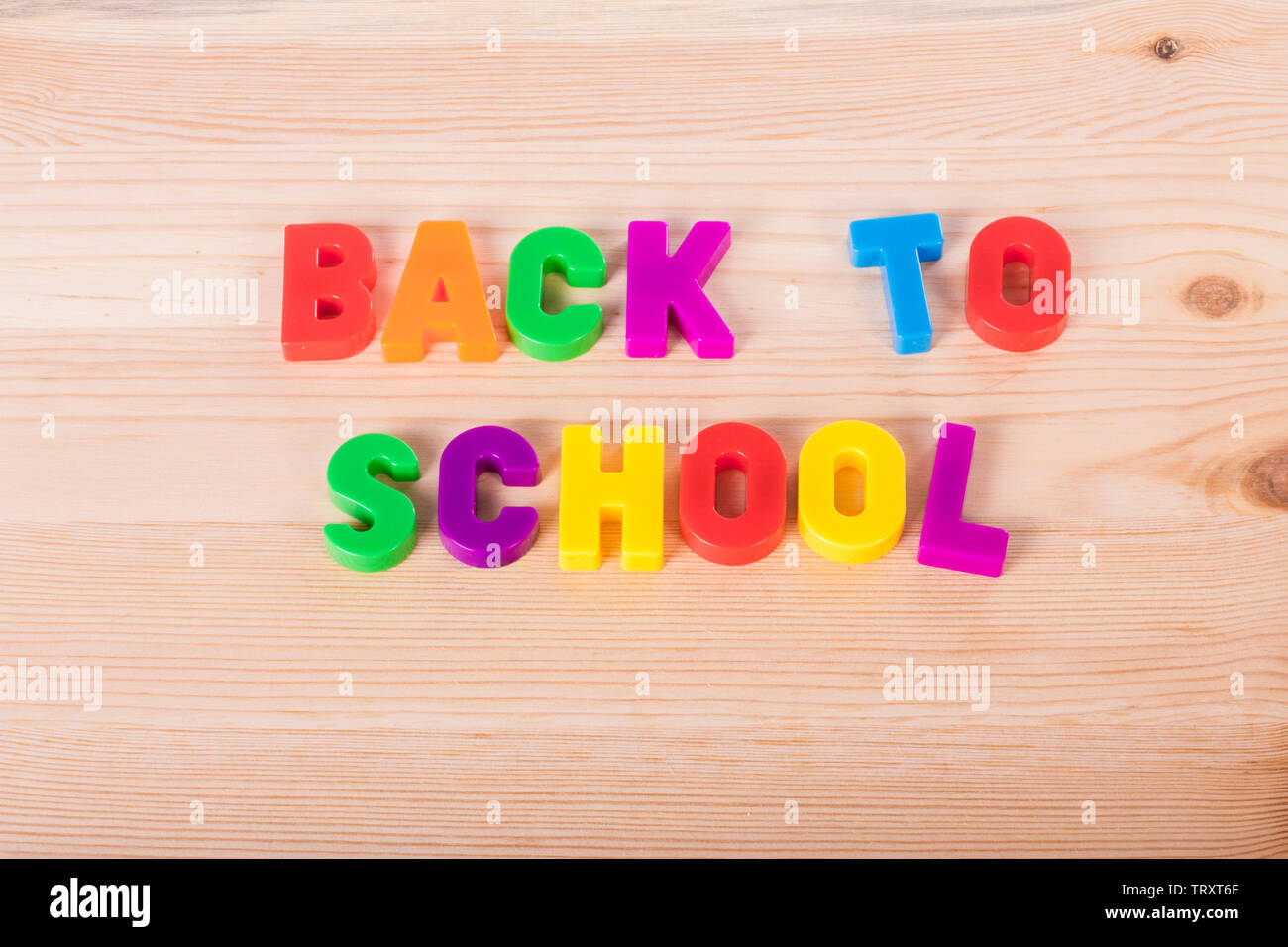 Back to school text written with magnetic coloured letters over a ...