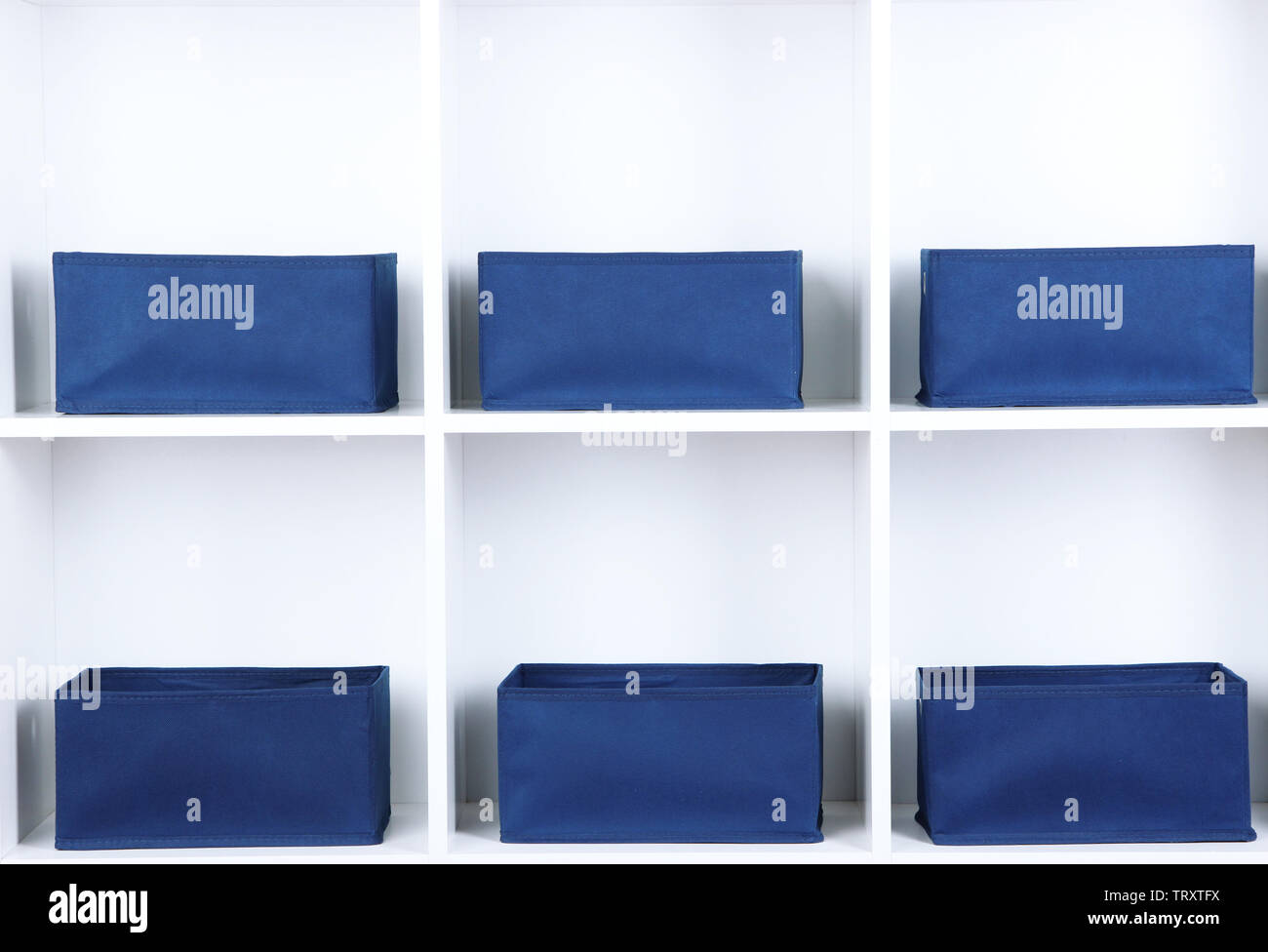 Blue textile boxes in white shelves Stock Photo - Alamy