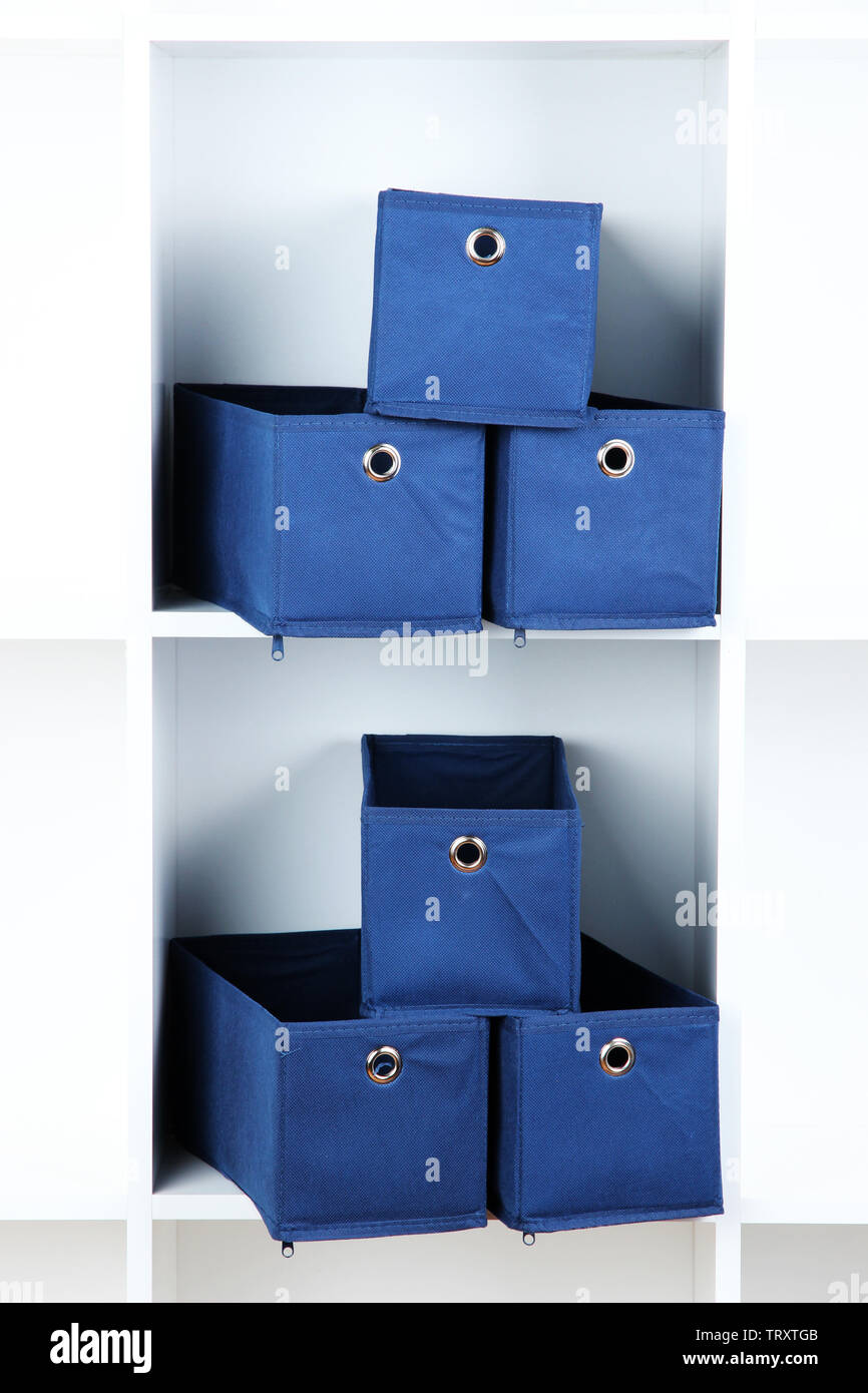 Blue textile boxes in white shelves Stock Photo - Alamy