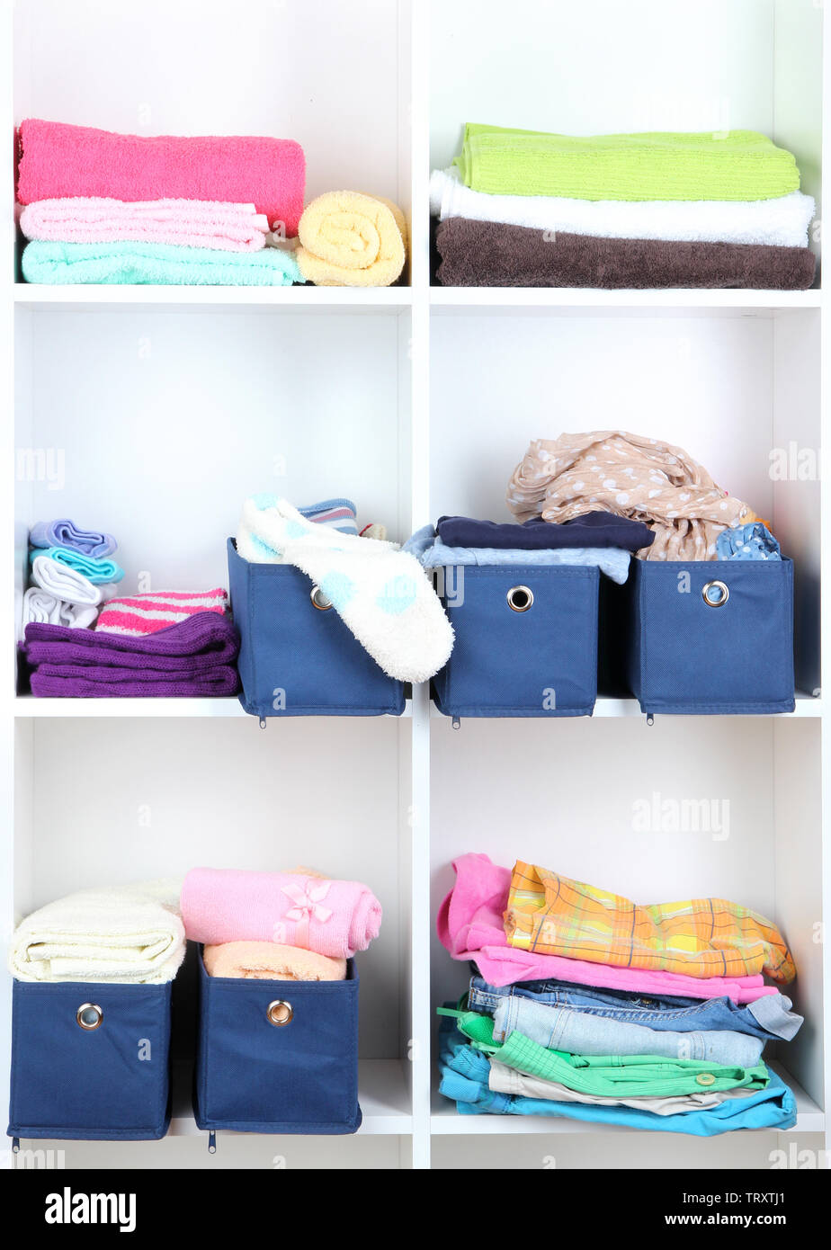 Blue textile boxes with towels and clothes in white shelves Stock Photo ...
