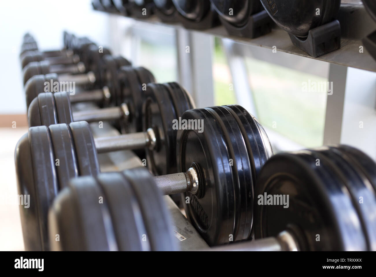Heavy black metal dumbbells lying in a row, closeup Stock Photo - Alamy
