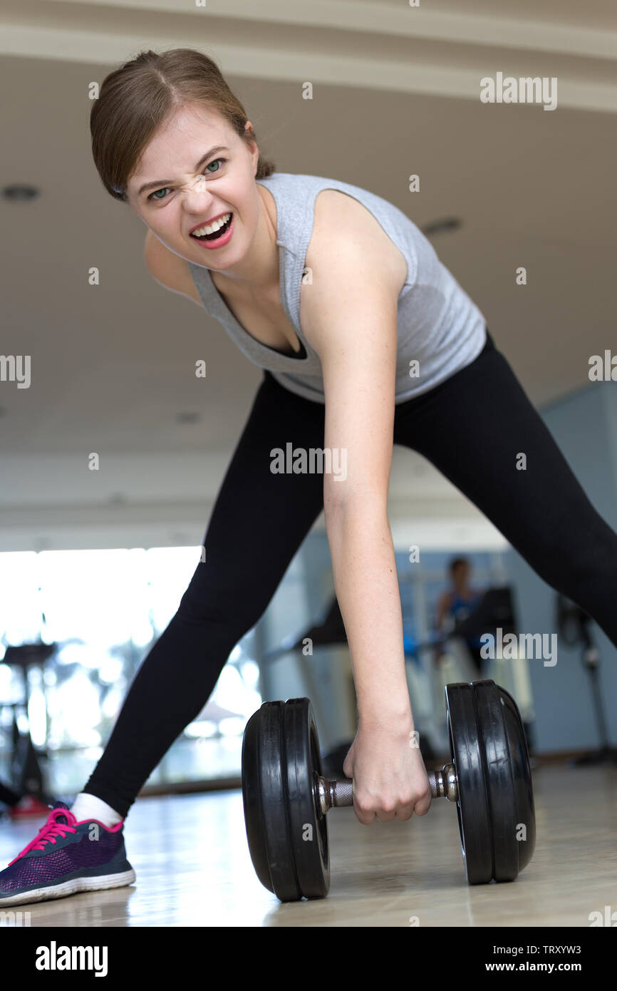 Young caucasian woman girl doing workout with light dumbbells at the ...