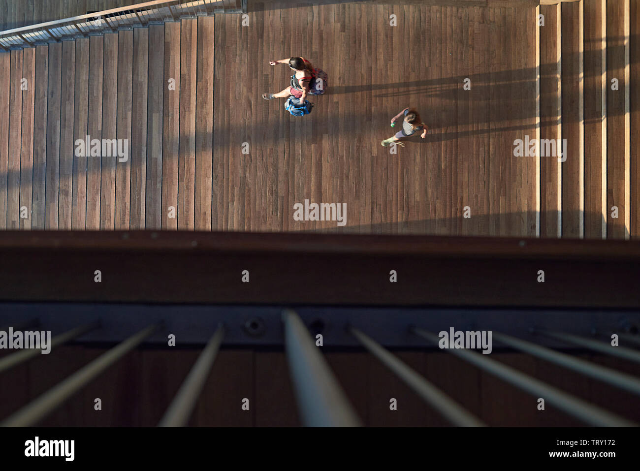 Top down shot of people walking on a large modern designer wooden ...