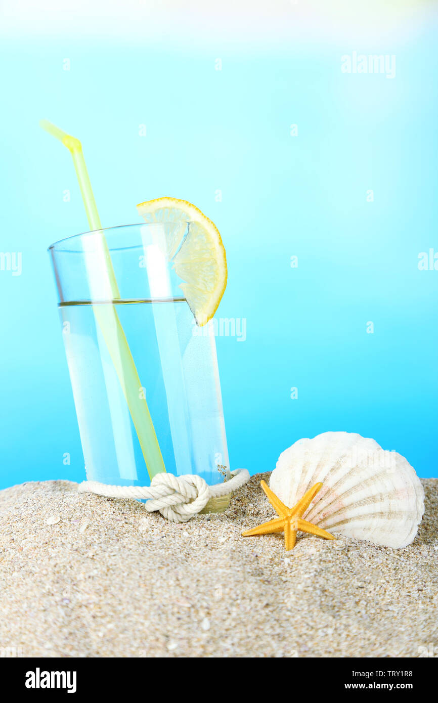 Beach cocktail in sand on blue background Stock Photo - Alamy