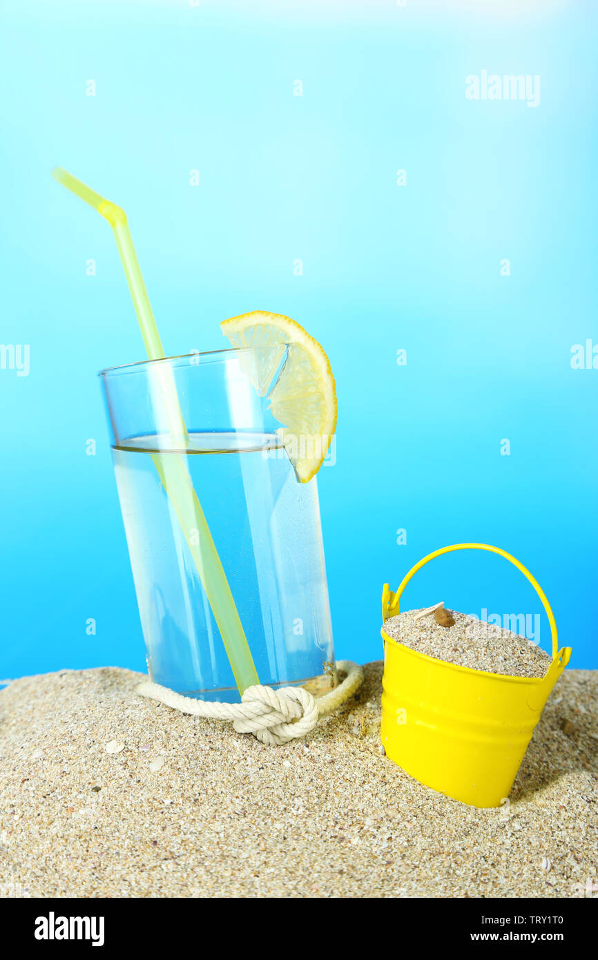 Beach cocktail in sand on blue background Stock Photo - Alamy