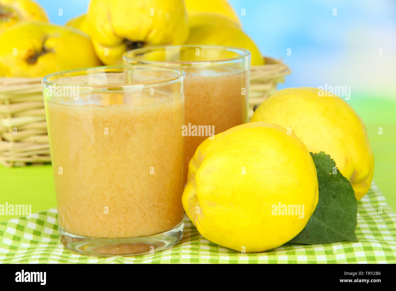 Sweet quince with juice on table on light blue background Stock Photo ...